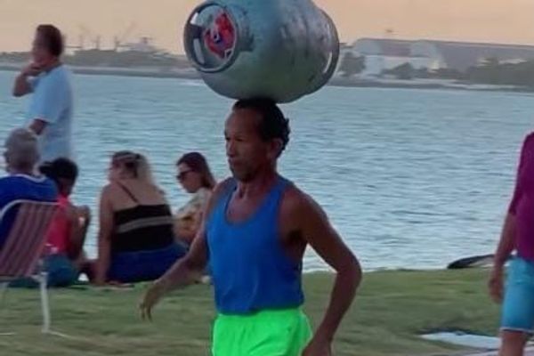 Homem corre com botijão de gás na cabeça na orla de Ponta Verde e ...